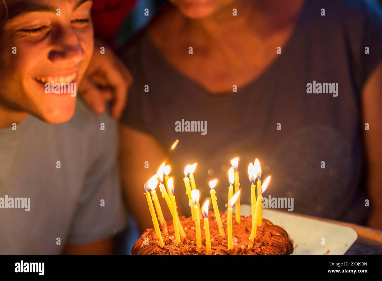 Close up of night party and birthday cake with candles. Young teenager ...