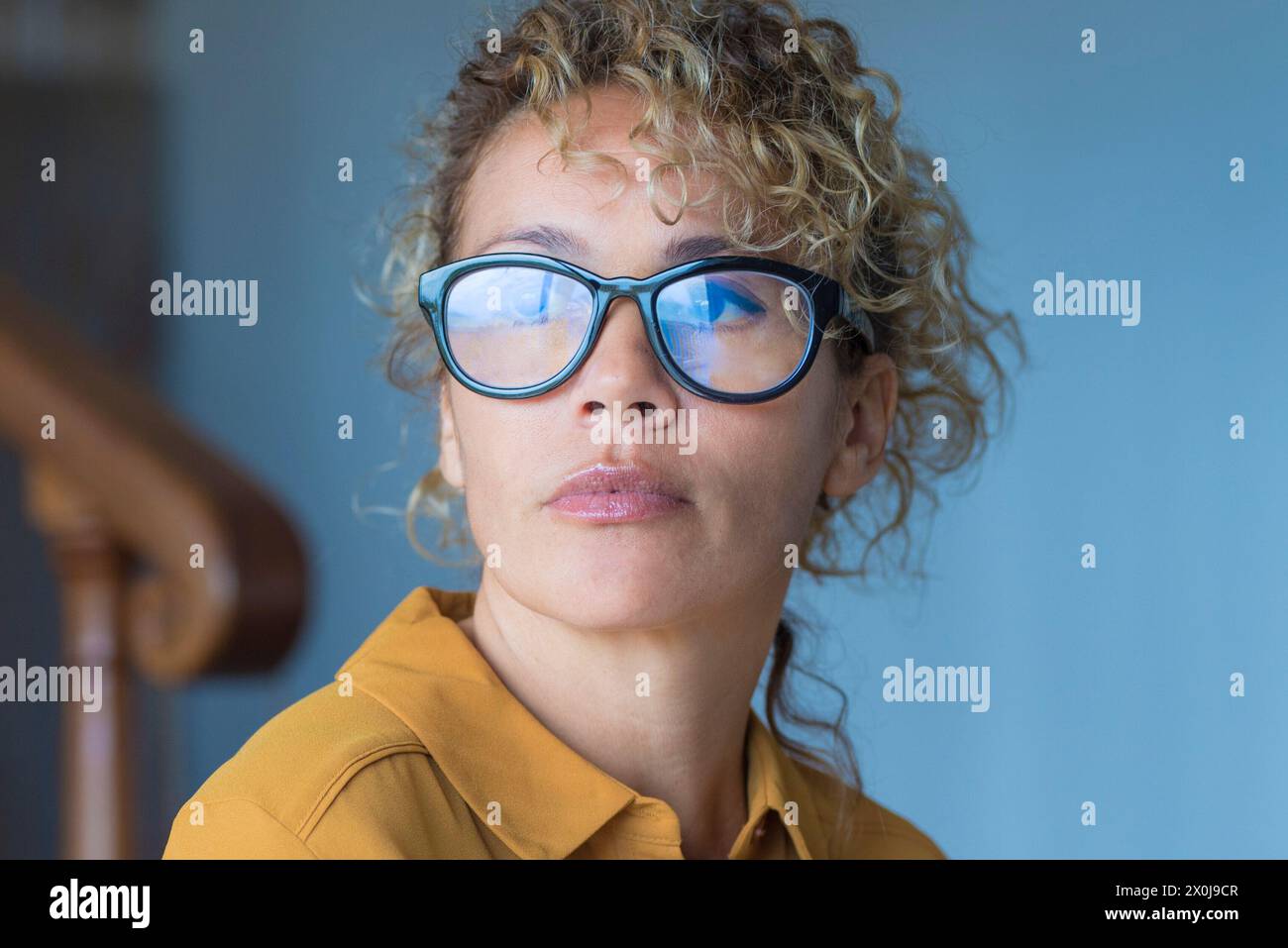 Portrait of thoughtful young adult woman with eyewear sitting on the ...