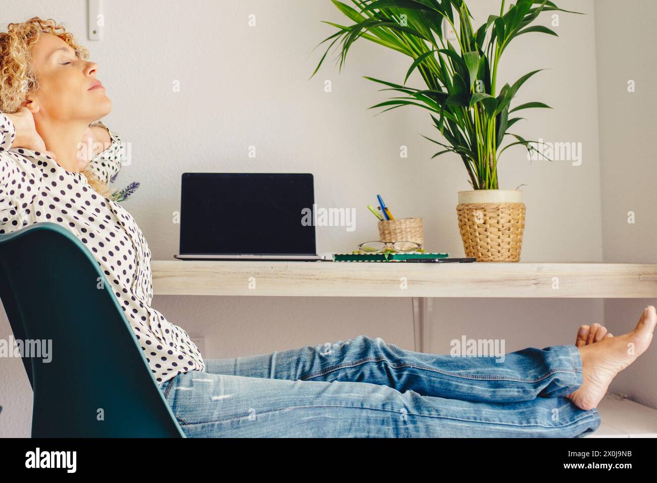 One adult woman at home having relax sitting on a chair stretching back ...