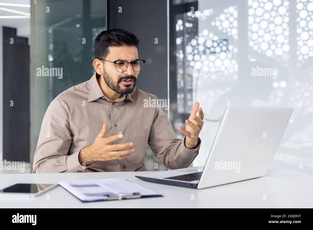 Indian businessman looking confused while gesturing during a discussion ...