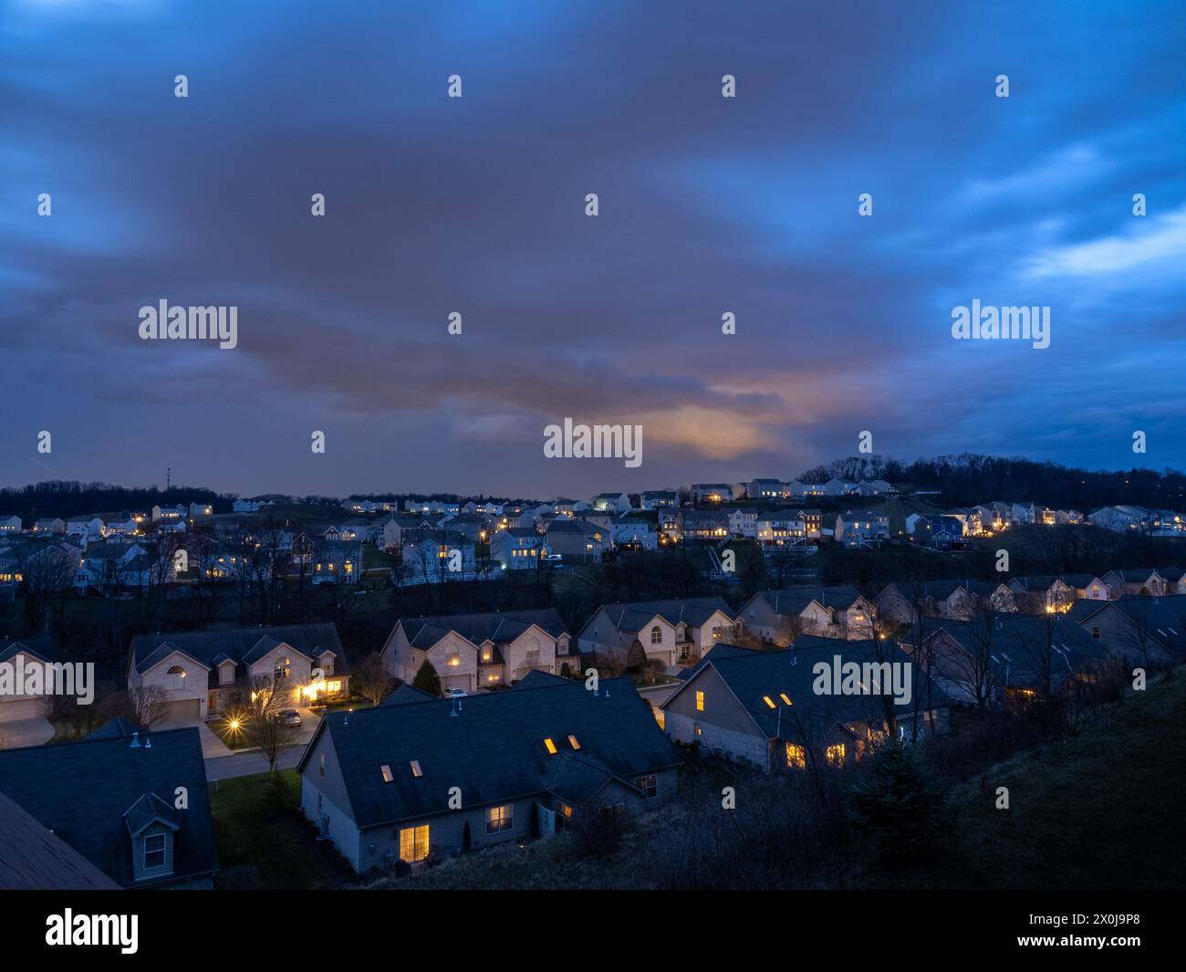 Aerial view: Dramatic clouds and glowing windows illuminate a US ...