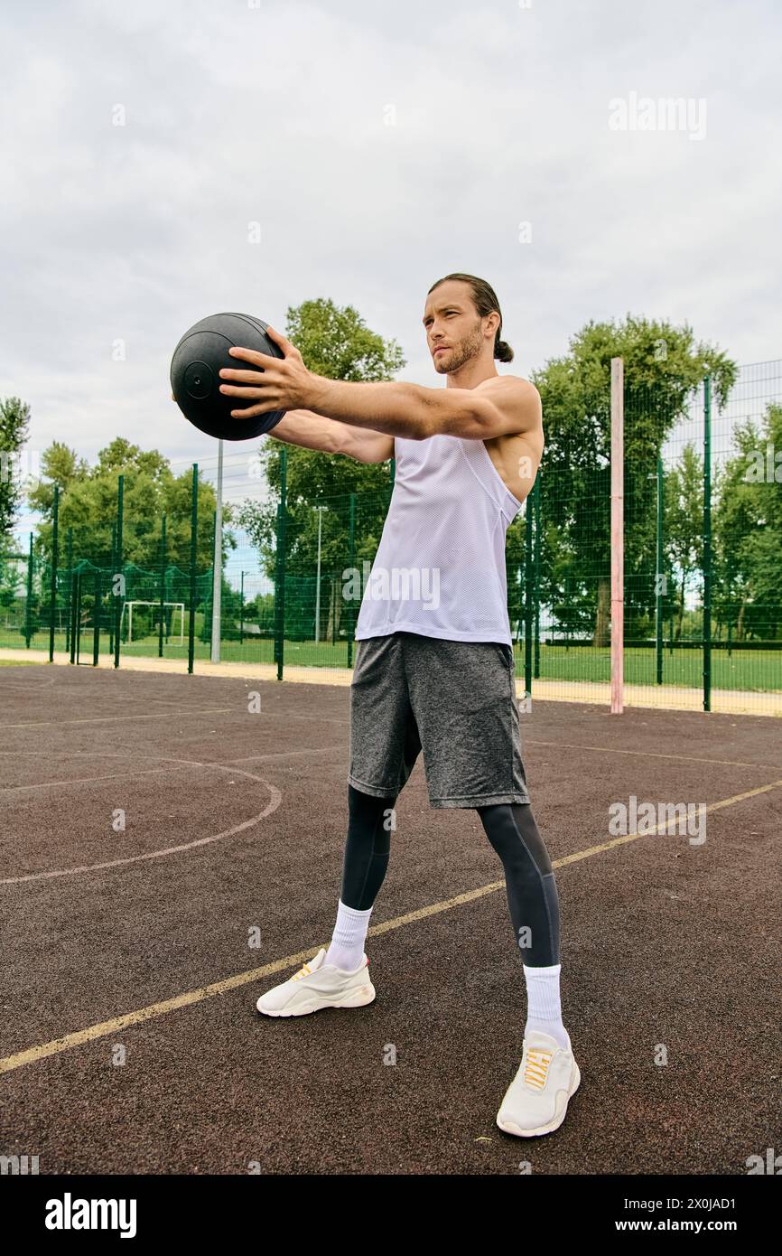 A man confidently holds a ball on top of a court, showcasing his ...