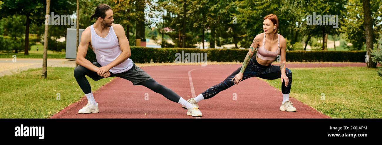 A woman in sportswear, guided by their personal trainer, display ...