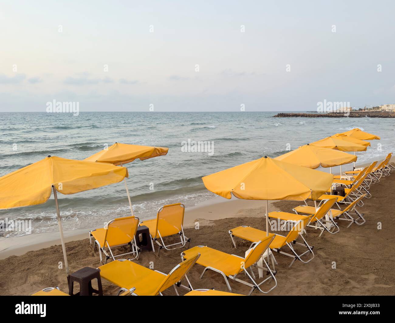 Empty sun loungers and parasols in the evening on the beach of Gouves ...