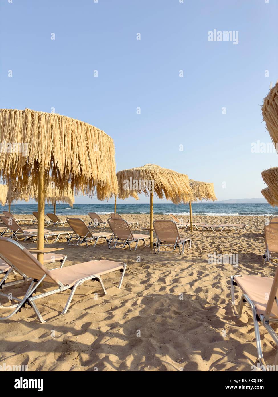Empty sun loungers in the early morning on the beach of Gouves on the ...