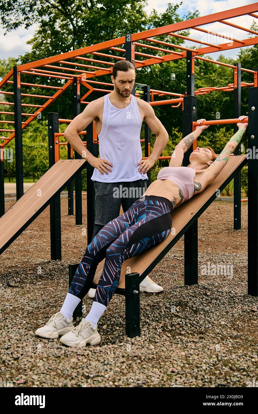 A determined man and woman in sportswear stand confidently on a wooden ...