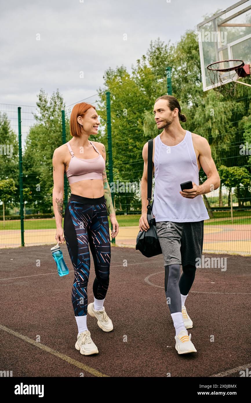 A determined man and woman in sportswear walk together on a basketball ...