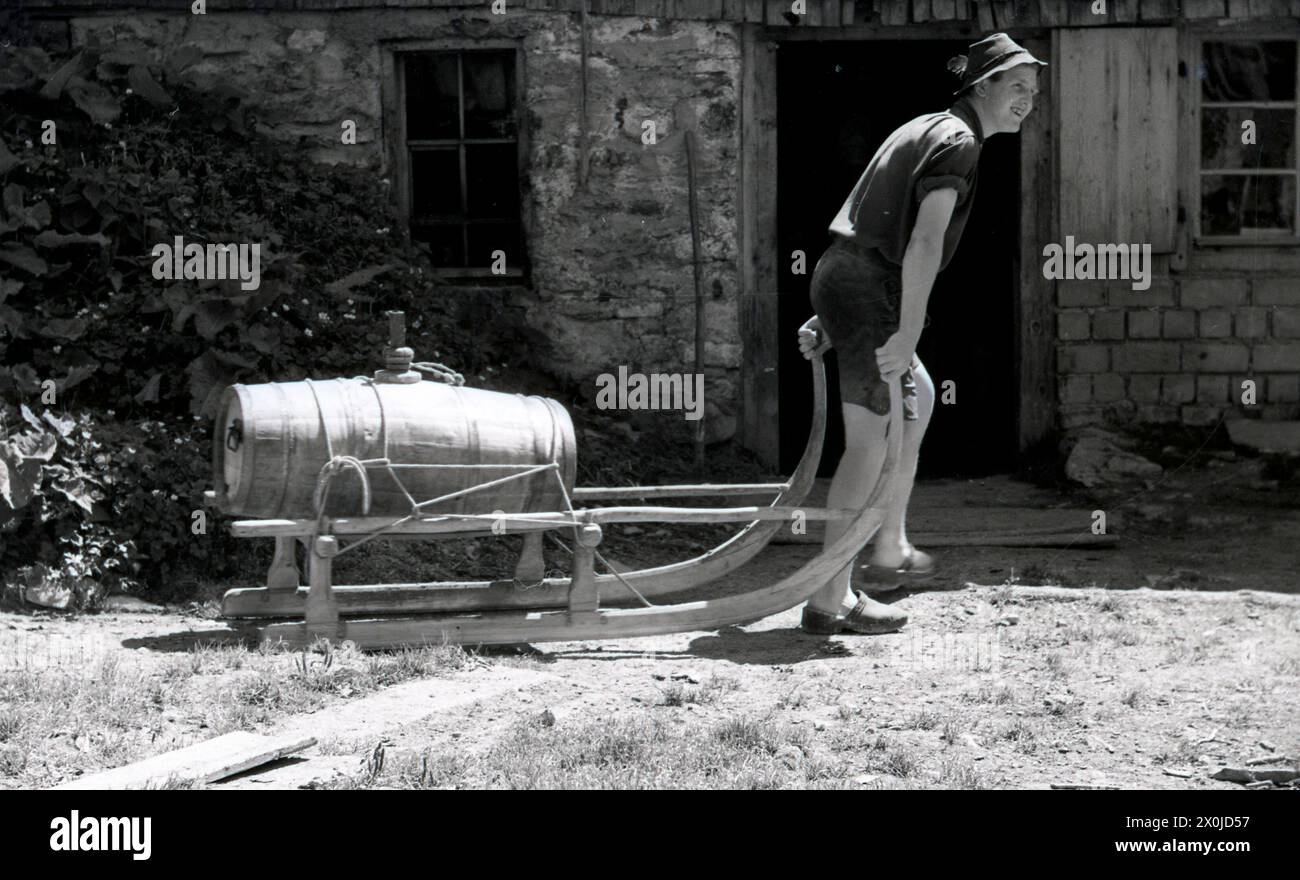 Milk barrel on sledge with dairyman Stock Photo - Alamy