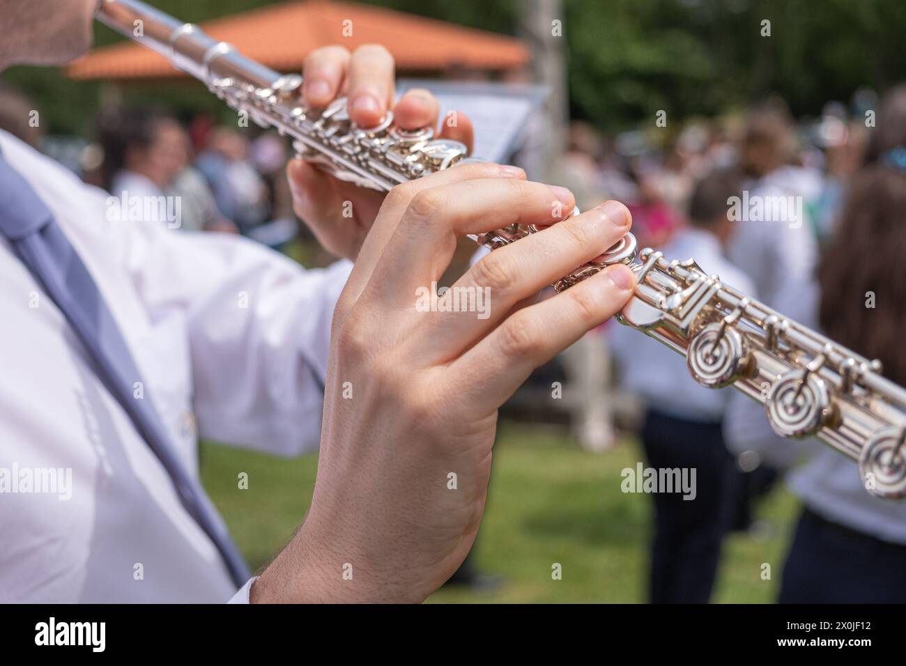 close-up view of a musician's hands playing a transverse flute at an ...