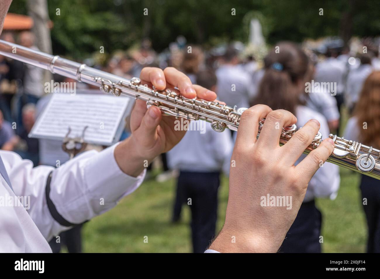 close-up view of a musician's hands playing a flute at an outdoor ...