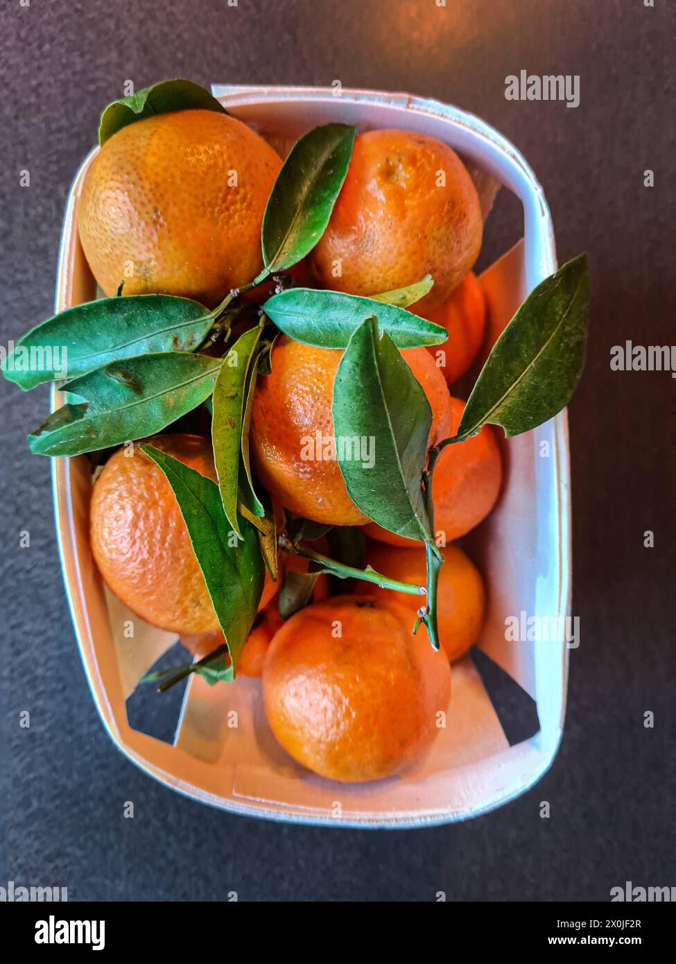 The orange fruits of the clementine or mandarins packed in a box with ...