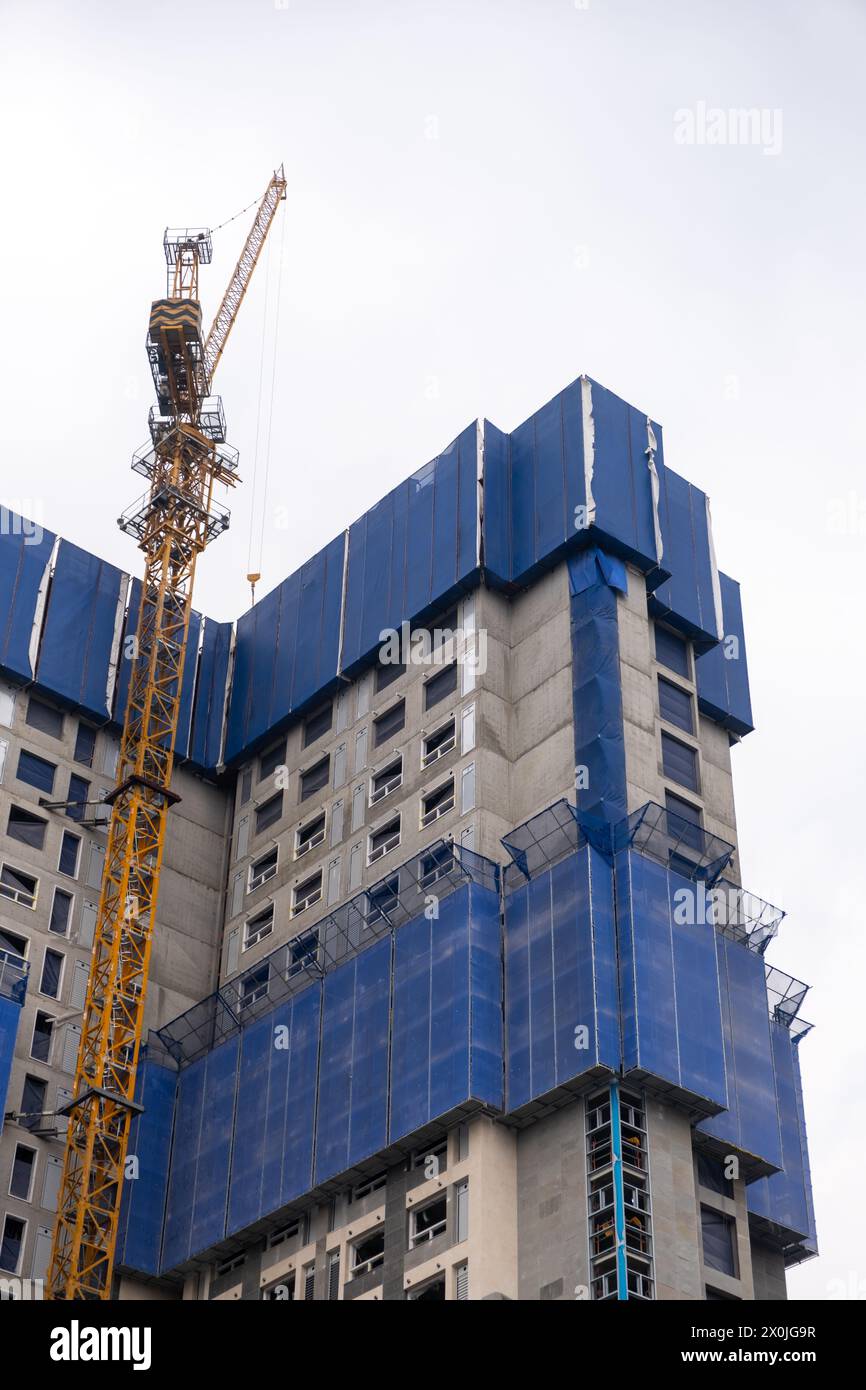 High-rise building under construction, wrapped in blue protection ...