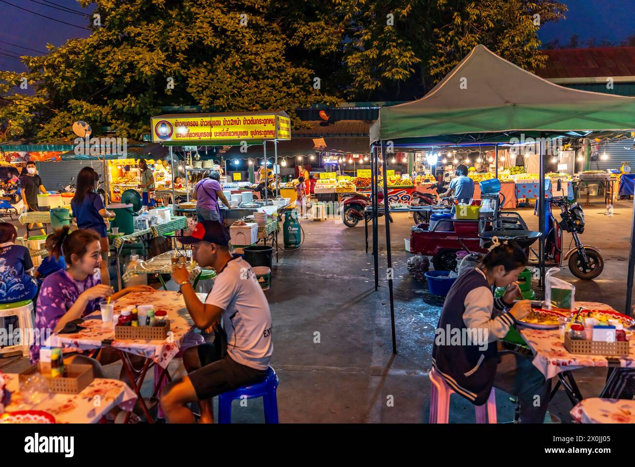 Night market with food stalls and tables at the Chom Thong Food Market ...