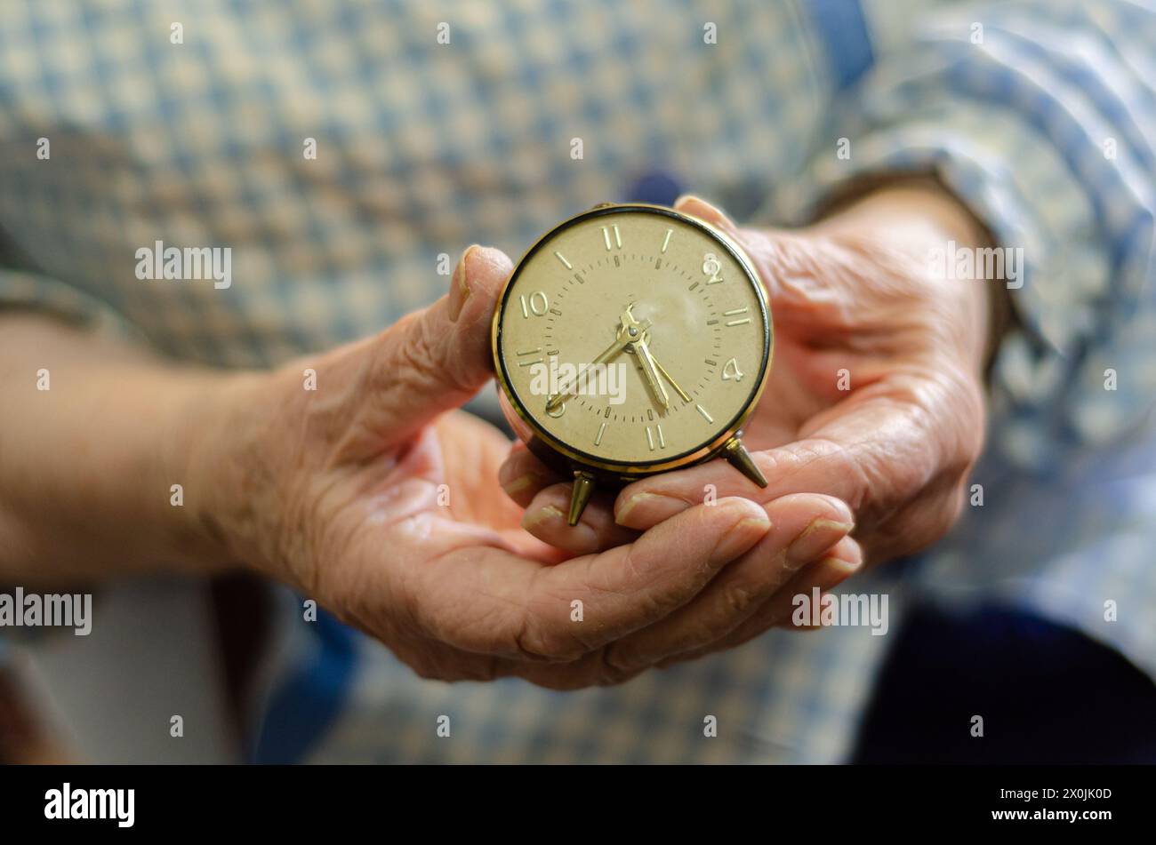 Grandmother holding an old watch in her hands. Concept of old age and ...