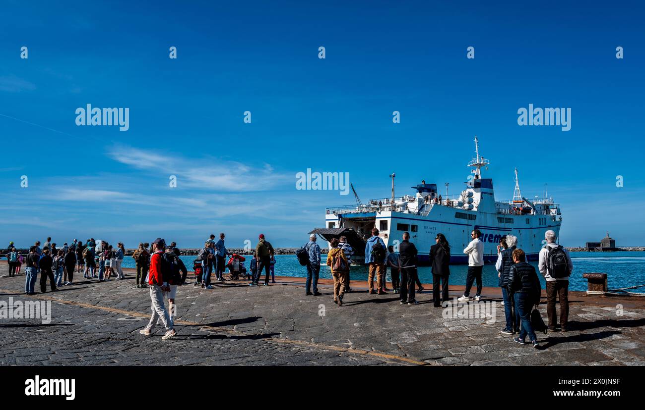 Crowd of people watching the Caremar ferry Driade arriving in Procida ...