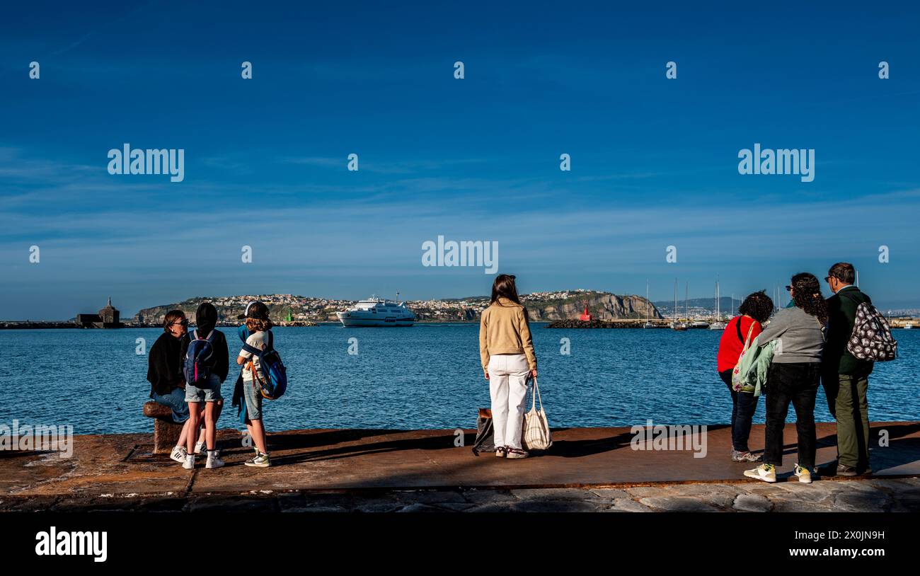 People watching the Caremar ferry Isola di Vulcano arriving in Procida ...