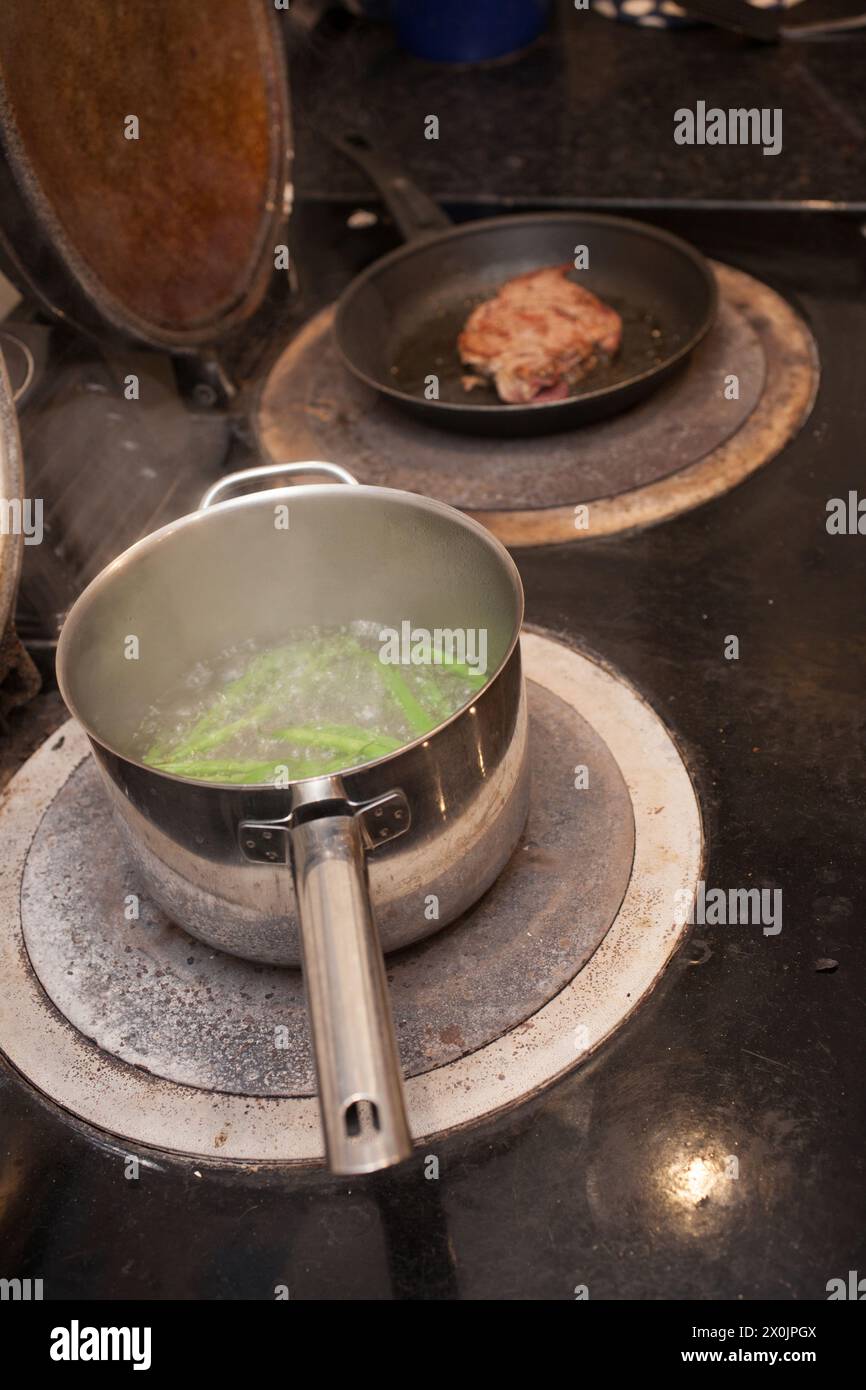 Cooking seperate dishes on an Aga, green beans and a beef steak Stock ...