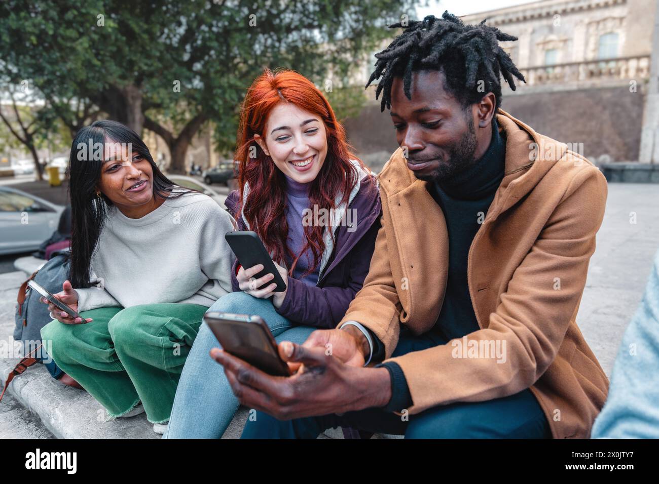 Multicultural friends trio enjoys a moment of urban camaraderie - young ...