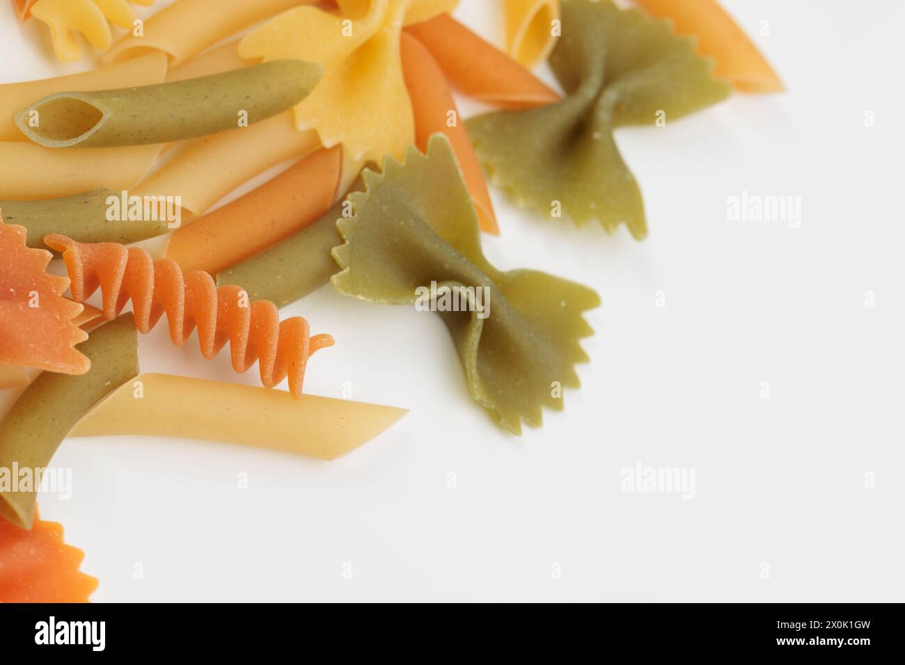 Tricolor macaroni of different types. It is located on a white surface ...