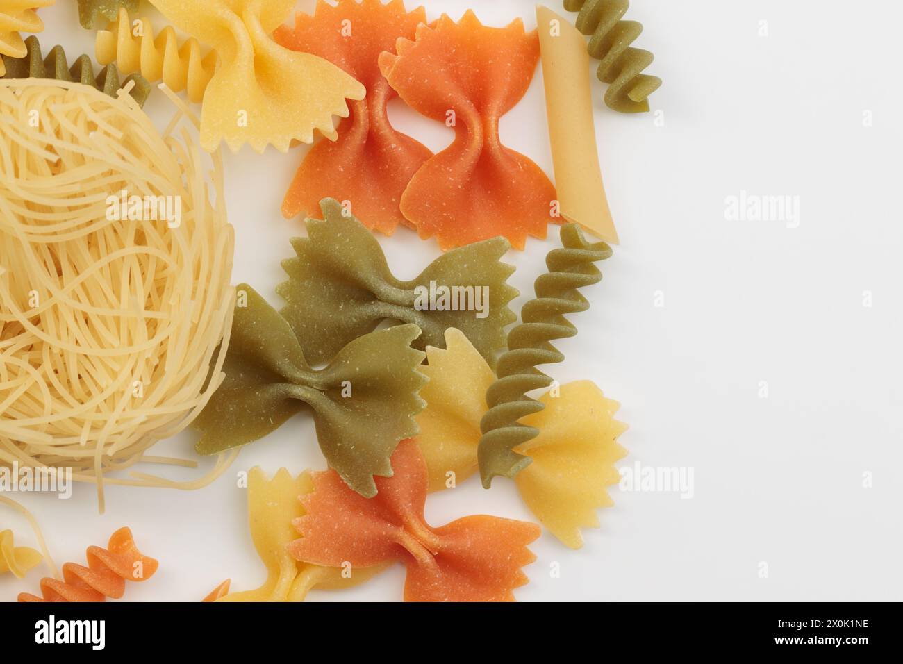 Tricolor macaroni of different types. It is located on a white surface ...