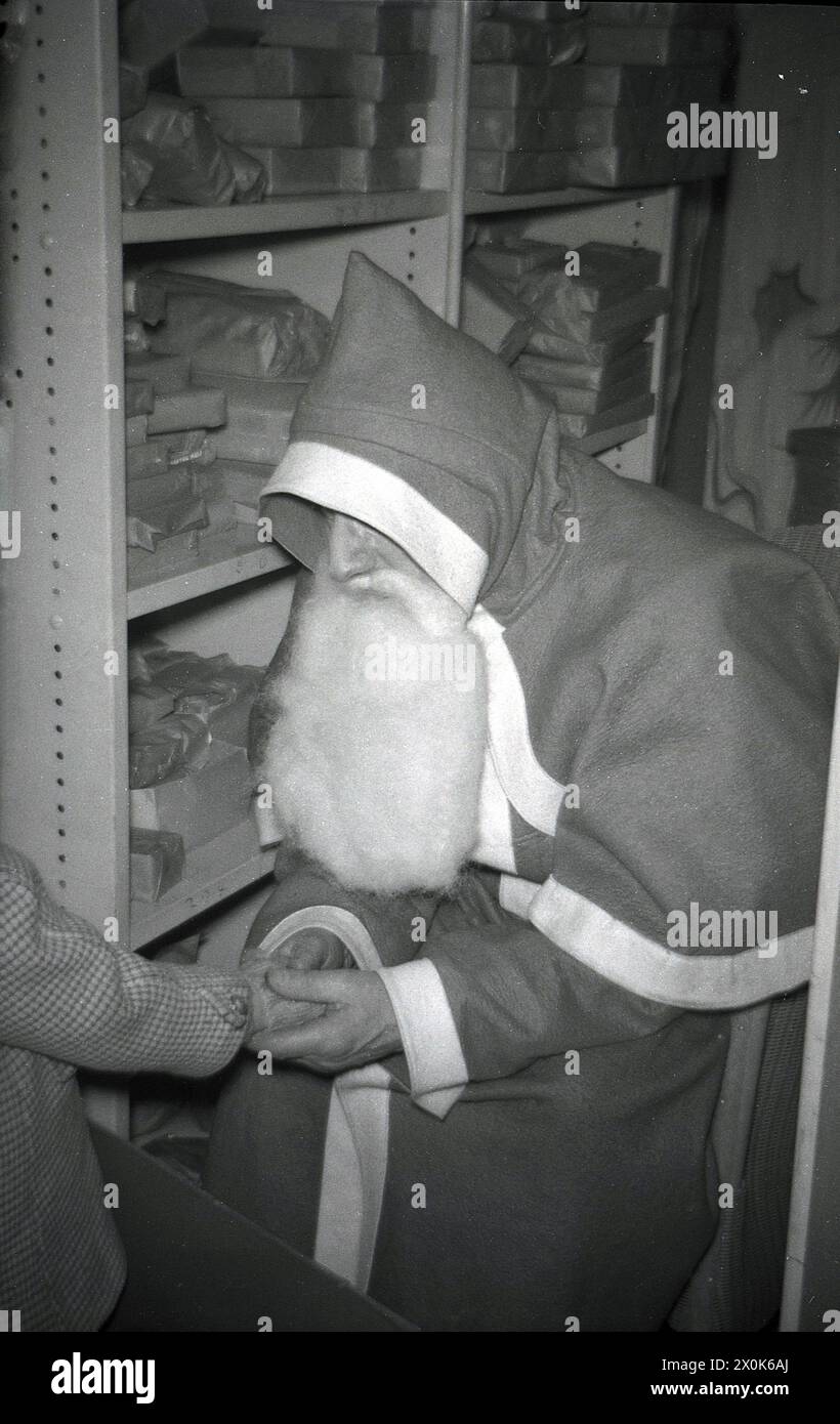 1960s, historical, father christmas holding a small boy's gloved hand ...