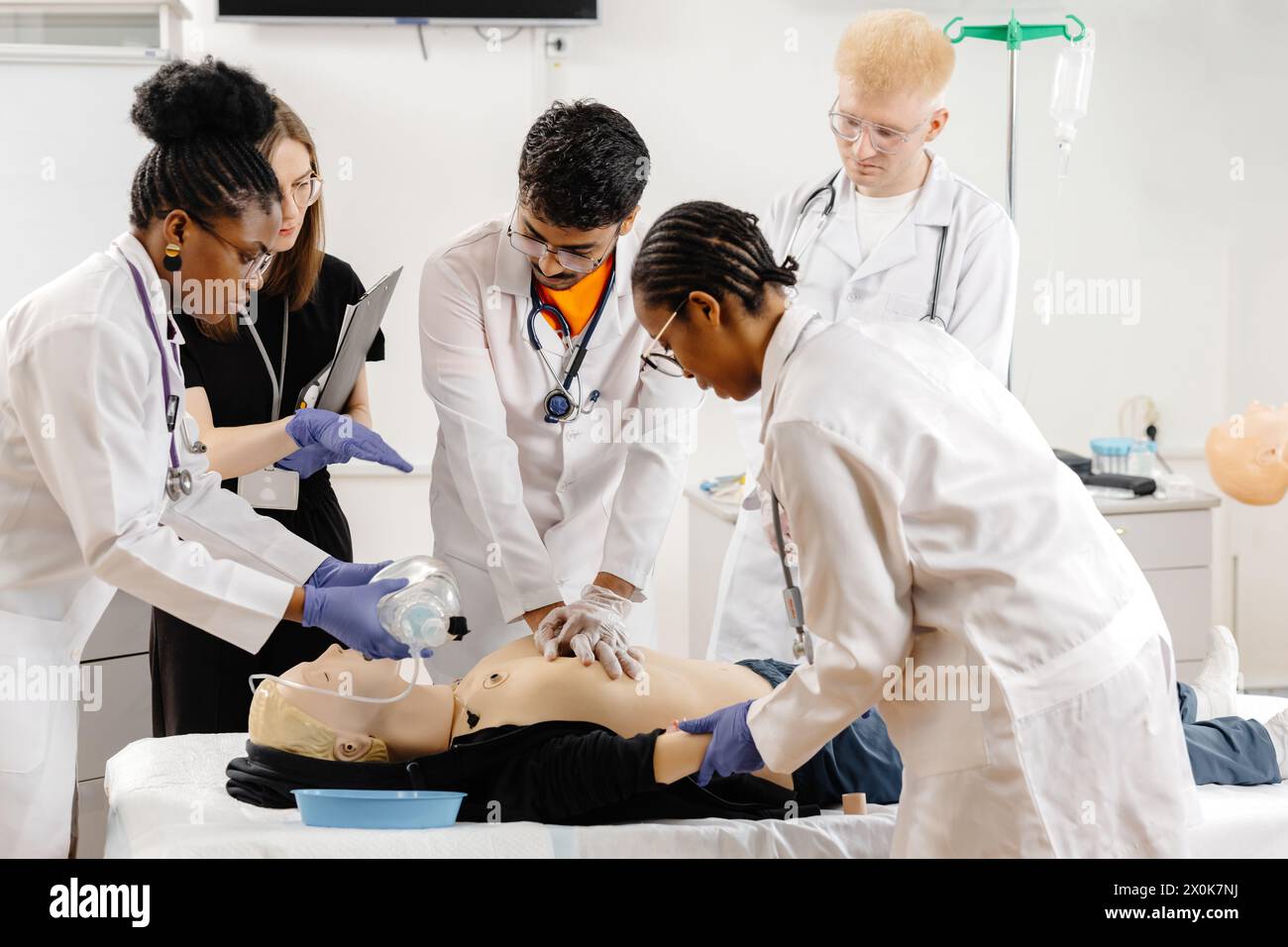 A team of medical professionals is gathered around a patient ...