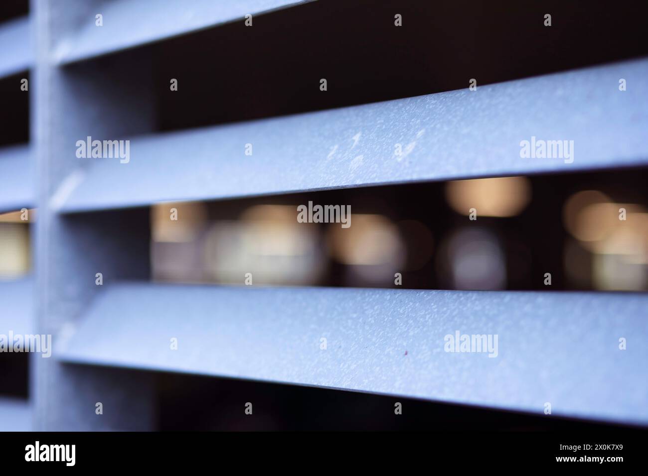 Metal barriers, car park fence, in the background blurred lights inside ...