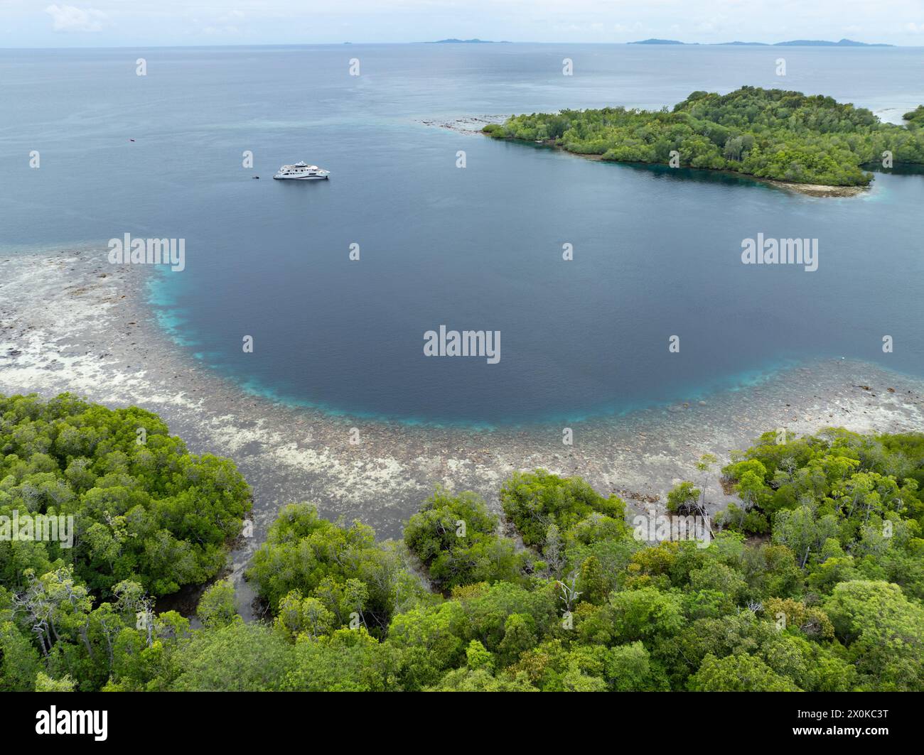 Healthy coral reefs grow along the edge of a channel between Gam and ...