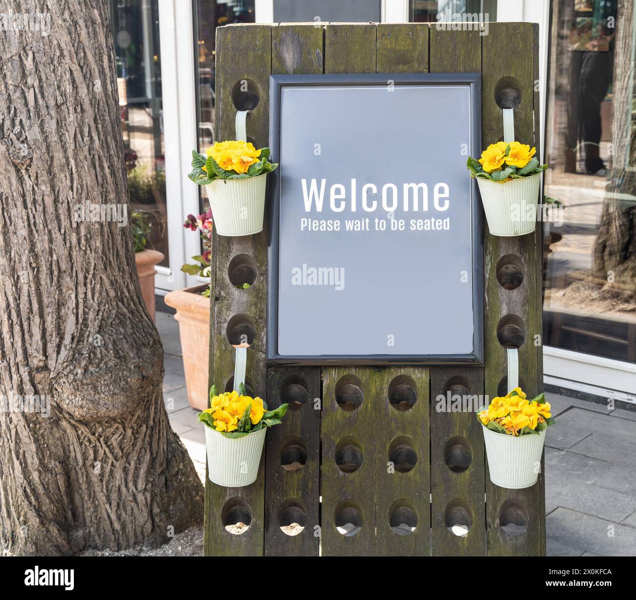 The sign outside the restaurant in English - Welcome, Please wait to be ...