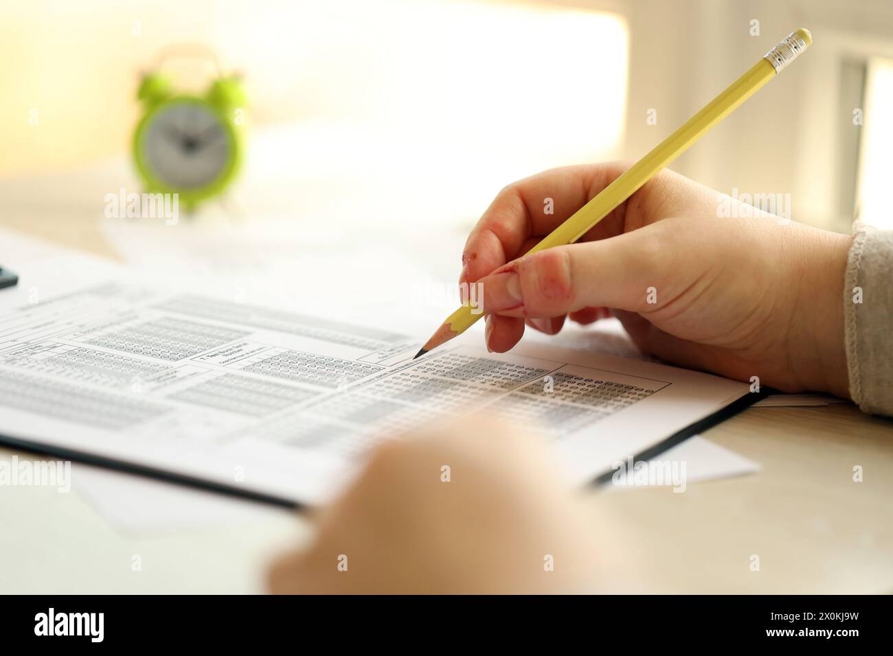 Female student hands testing in exercise and taking fill in exam paper ...