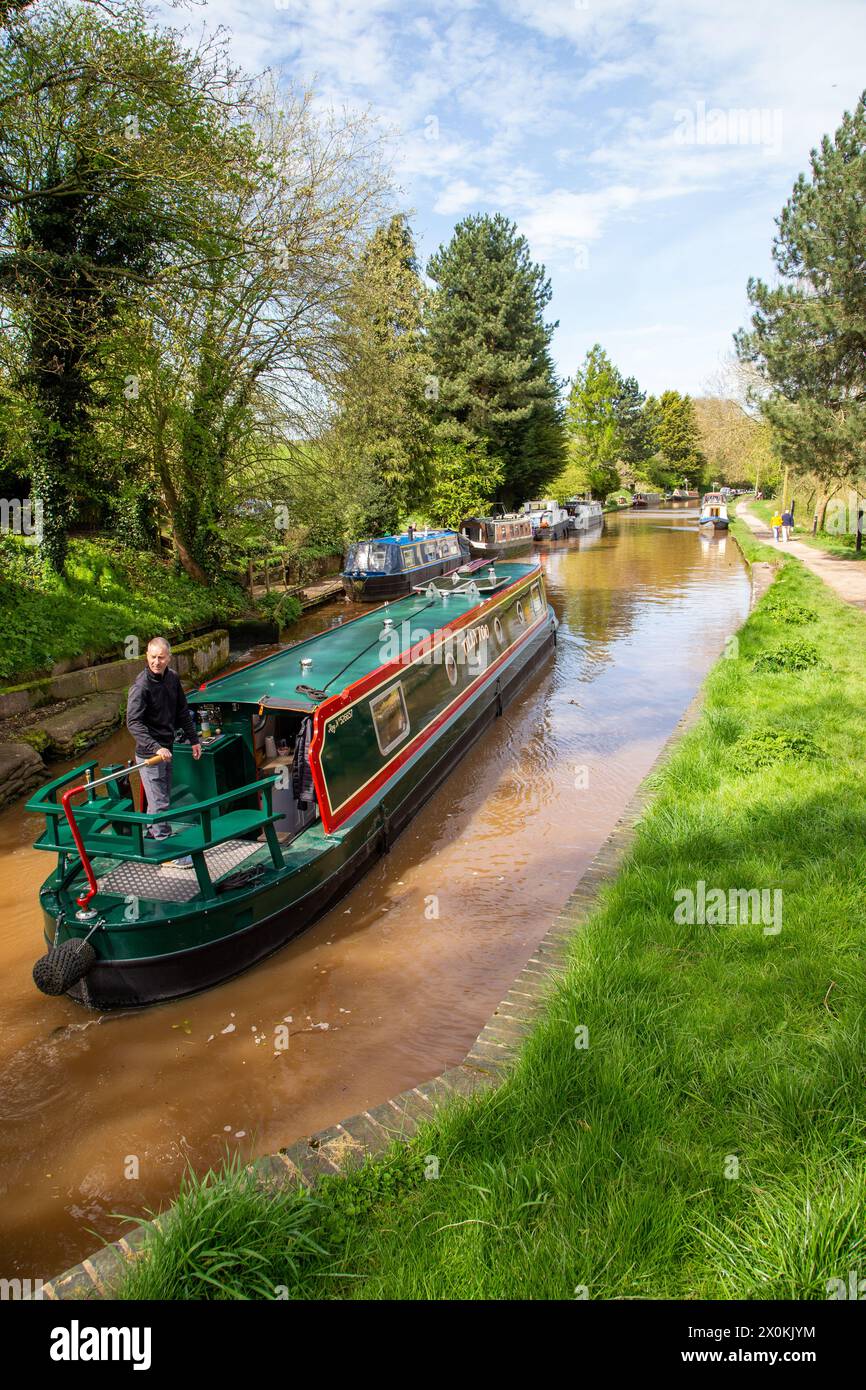 Man steering canal narrowboat along the Shropshire union canal in the ...
