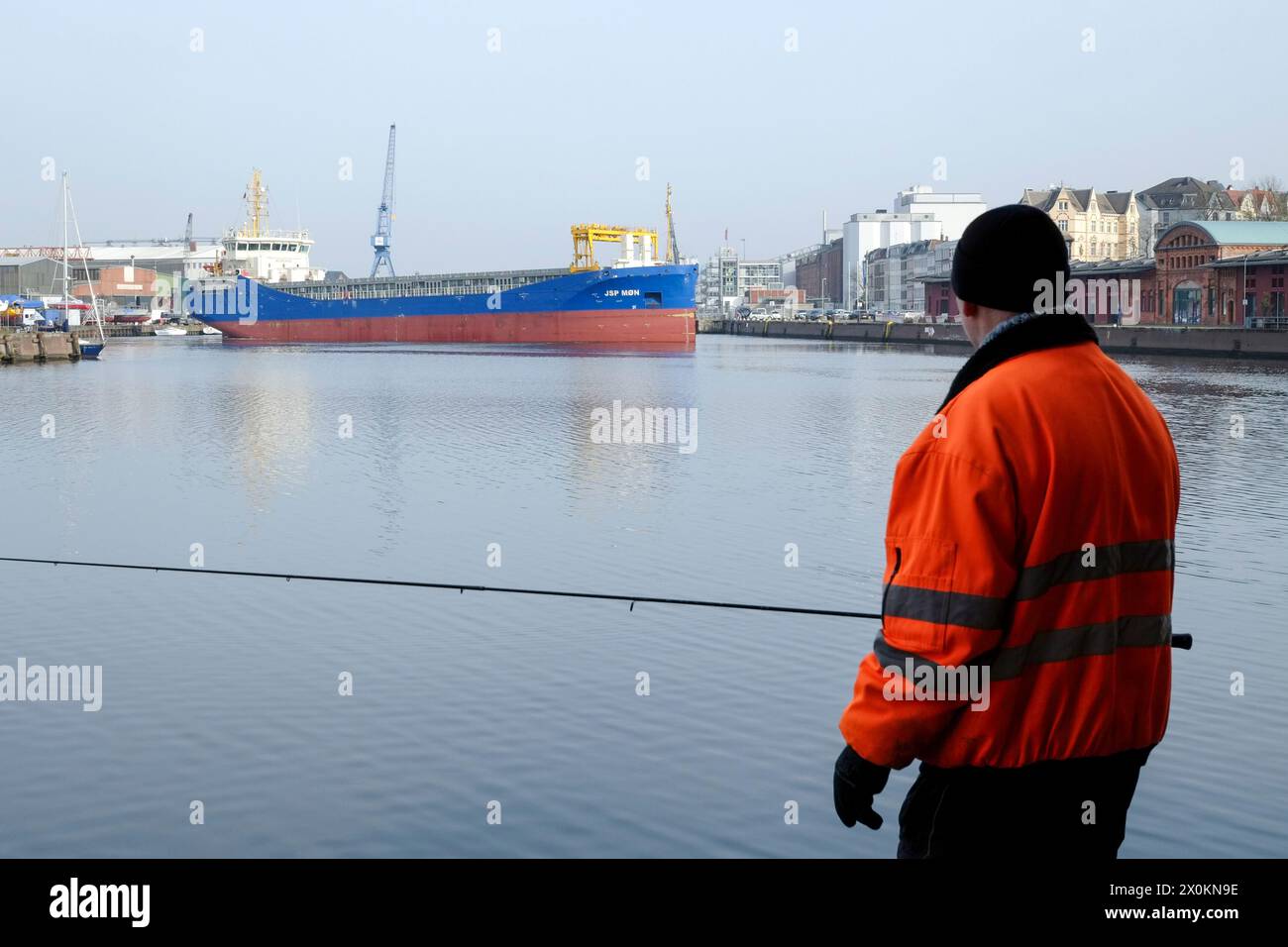 Cargo ship and angler Stock Photo - Alamy