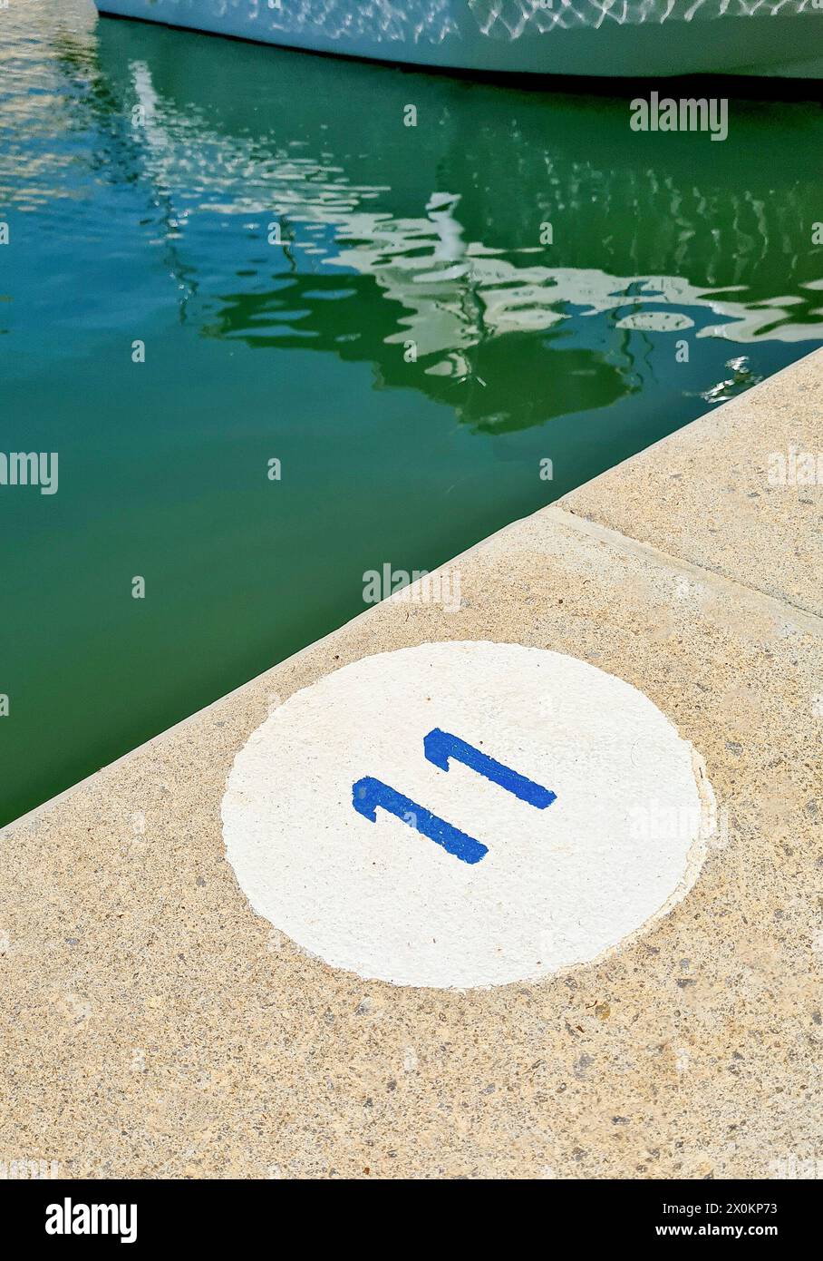 A white round circle with a blue number 11, marking on stone floor ...