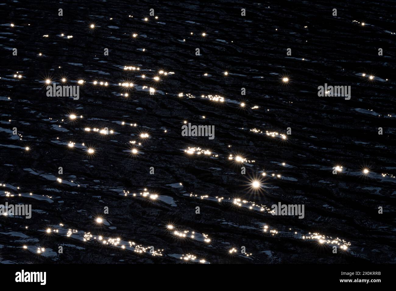 Light reflections caused by sunlight on the surface of a lake, small ...