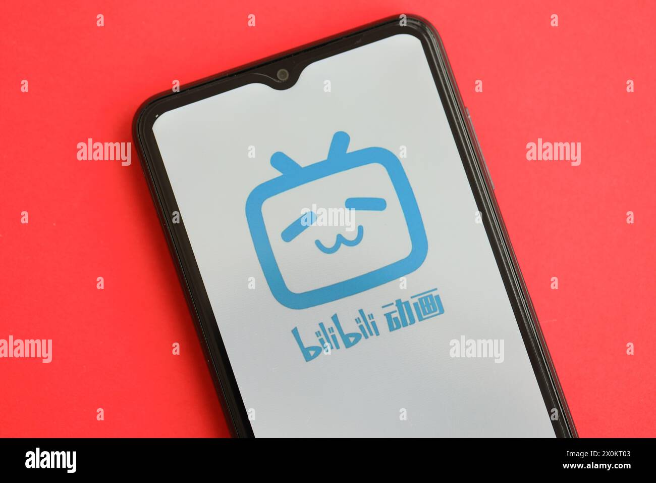 KYIV, UKRAINE - APRIL 1, 2024 Bilibili icon on smartphone screen on red table close up. iPhone ...