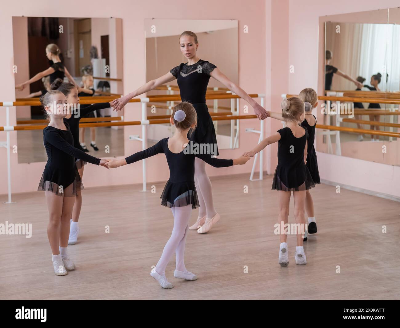 Children's ballet school. Caucasian woman teaching ballet to little ...