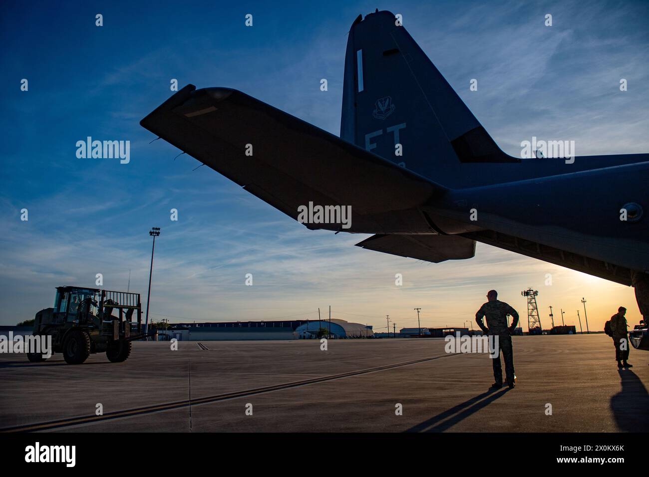A U.S. Air Force Airman waits for a forklift to unload cargo from an HC ...