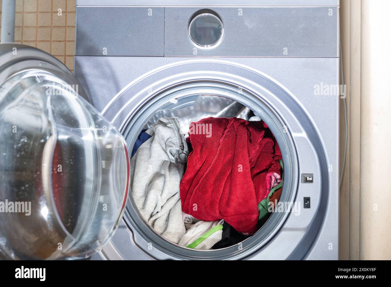 front-loading washing machine filled with clothes and about to start ...