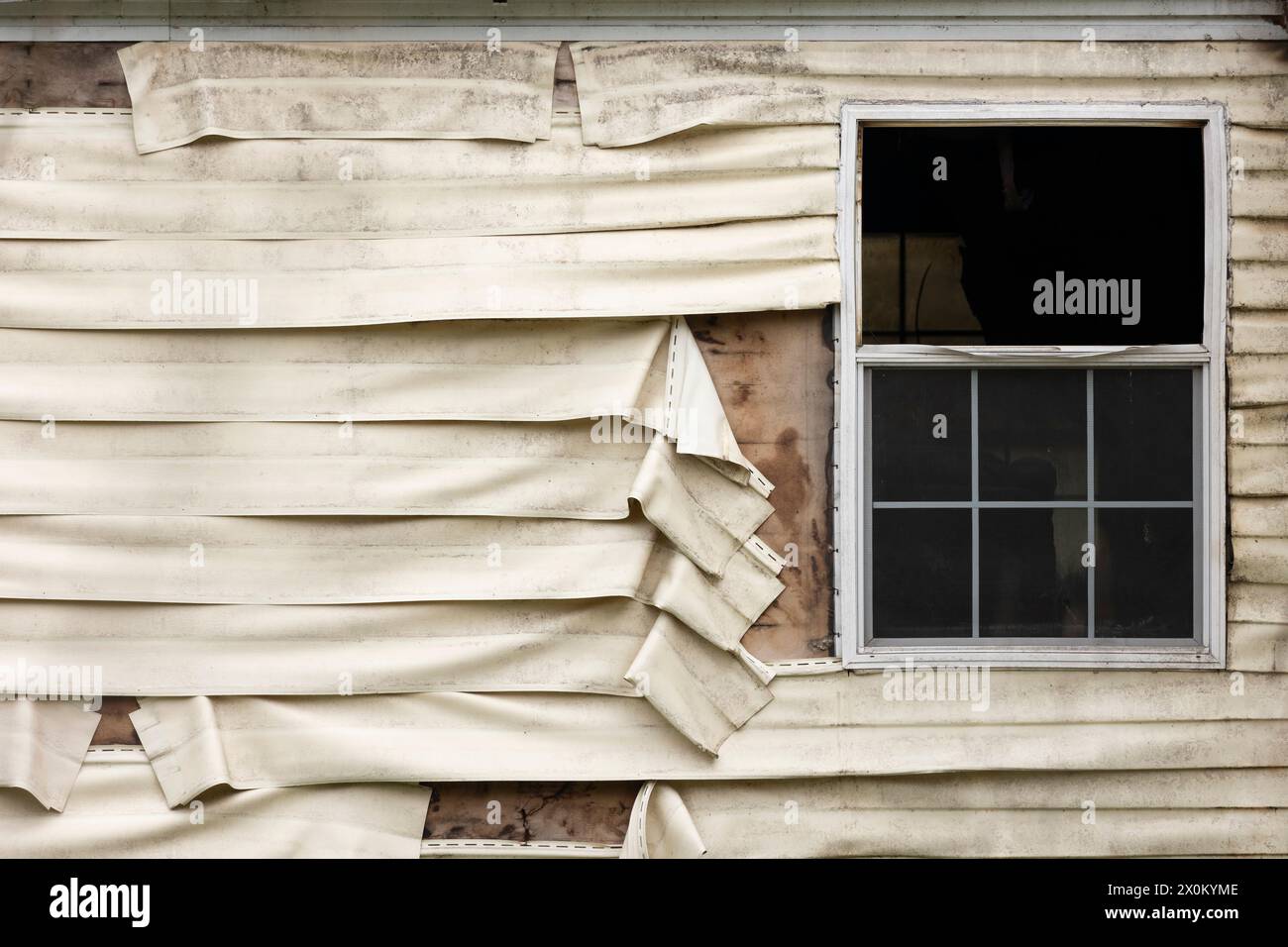 An open exterior window with damaged and melted plastic vinyl siding ...