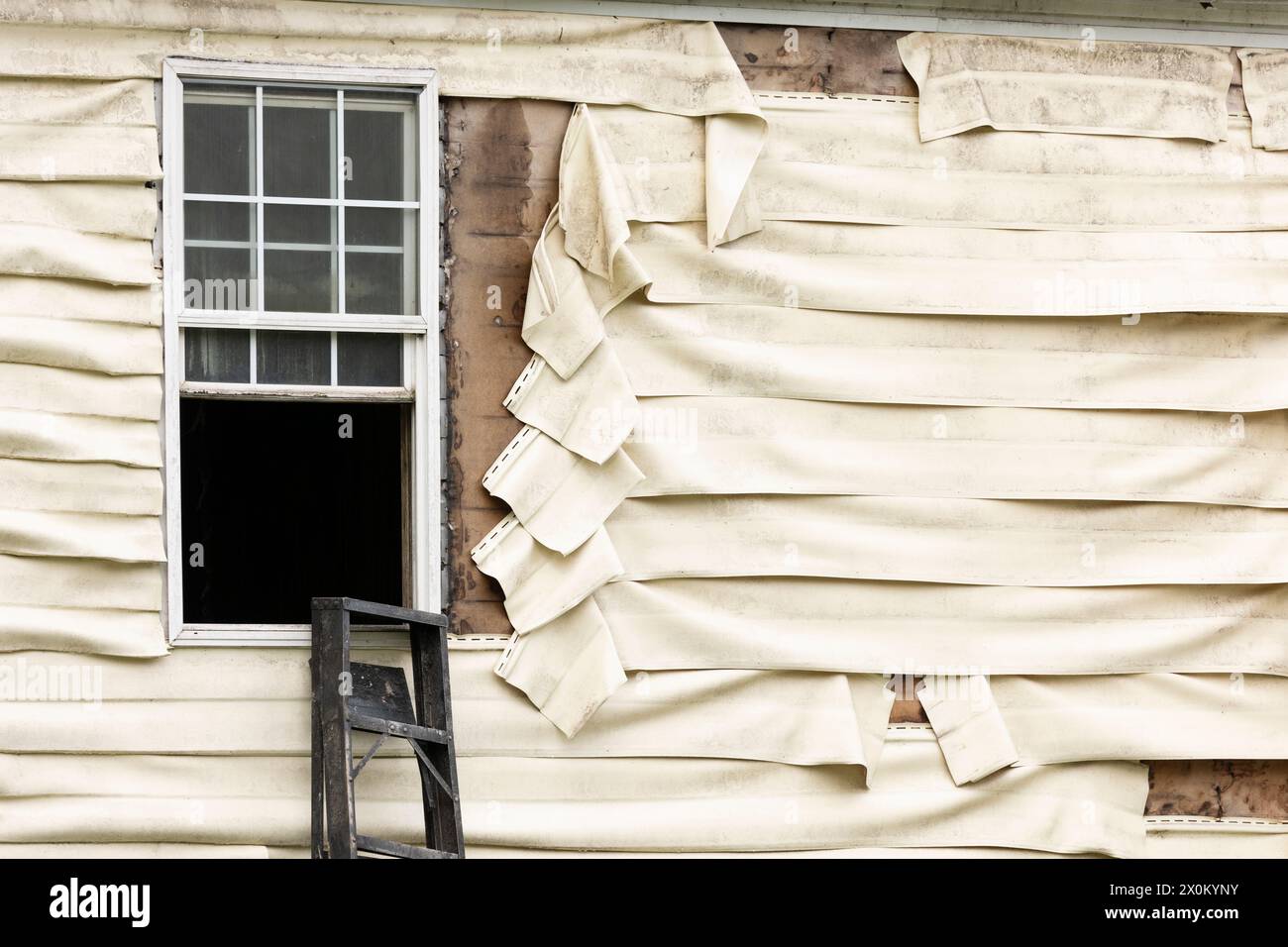 An open exterior window with damaged and melted plastic vinyl siding ...