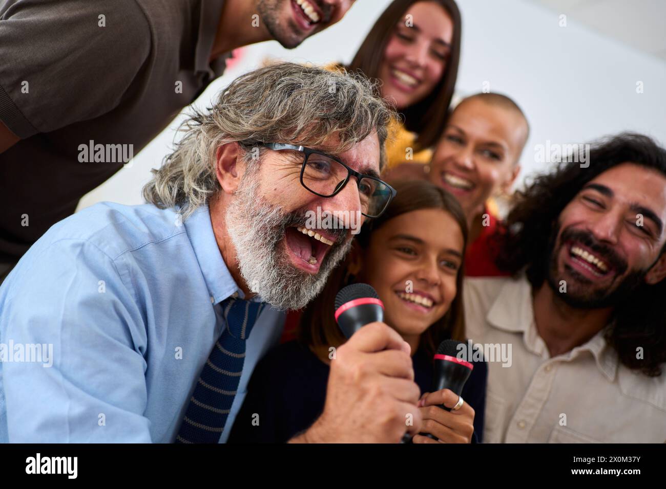 Funny Caucasian family playing Sing Star karaoke holding microphones ...