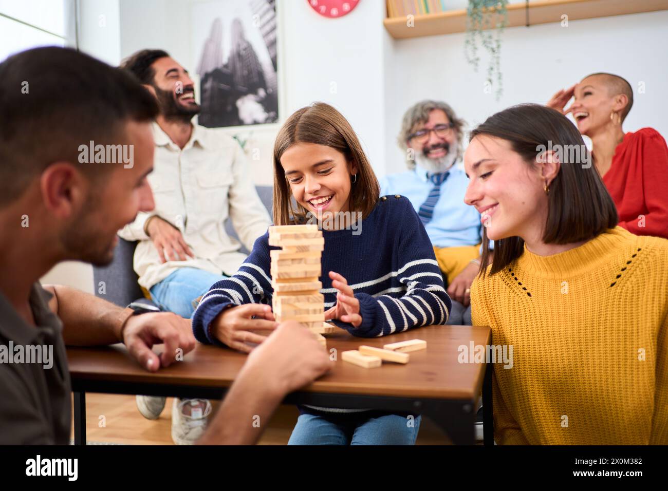 Happy diverse generation family gathered playing Jenga at home ...