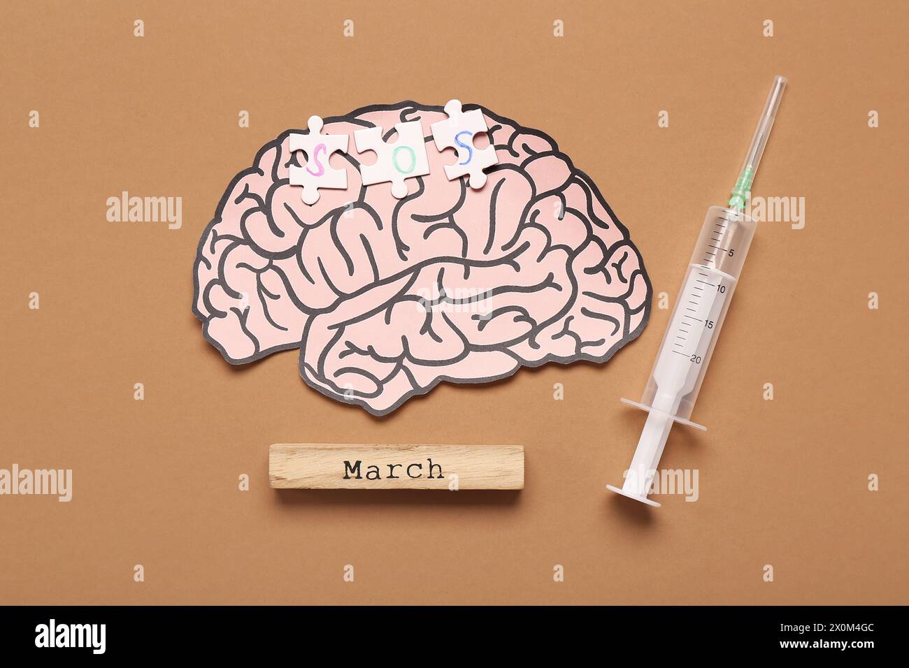 Paper brain with puzzle pieces, syringe and word MARCH on brown ...