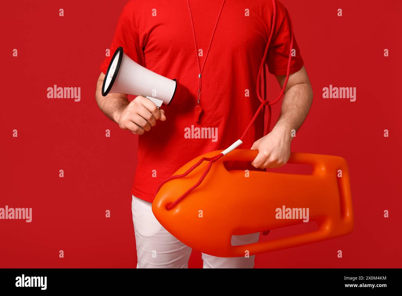 Male lifeguard with rescue tube buoy and megaphone on red background ...