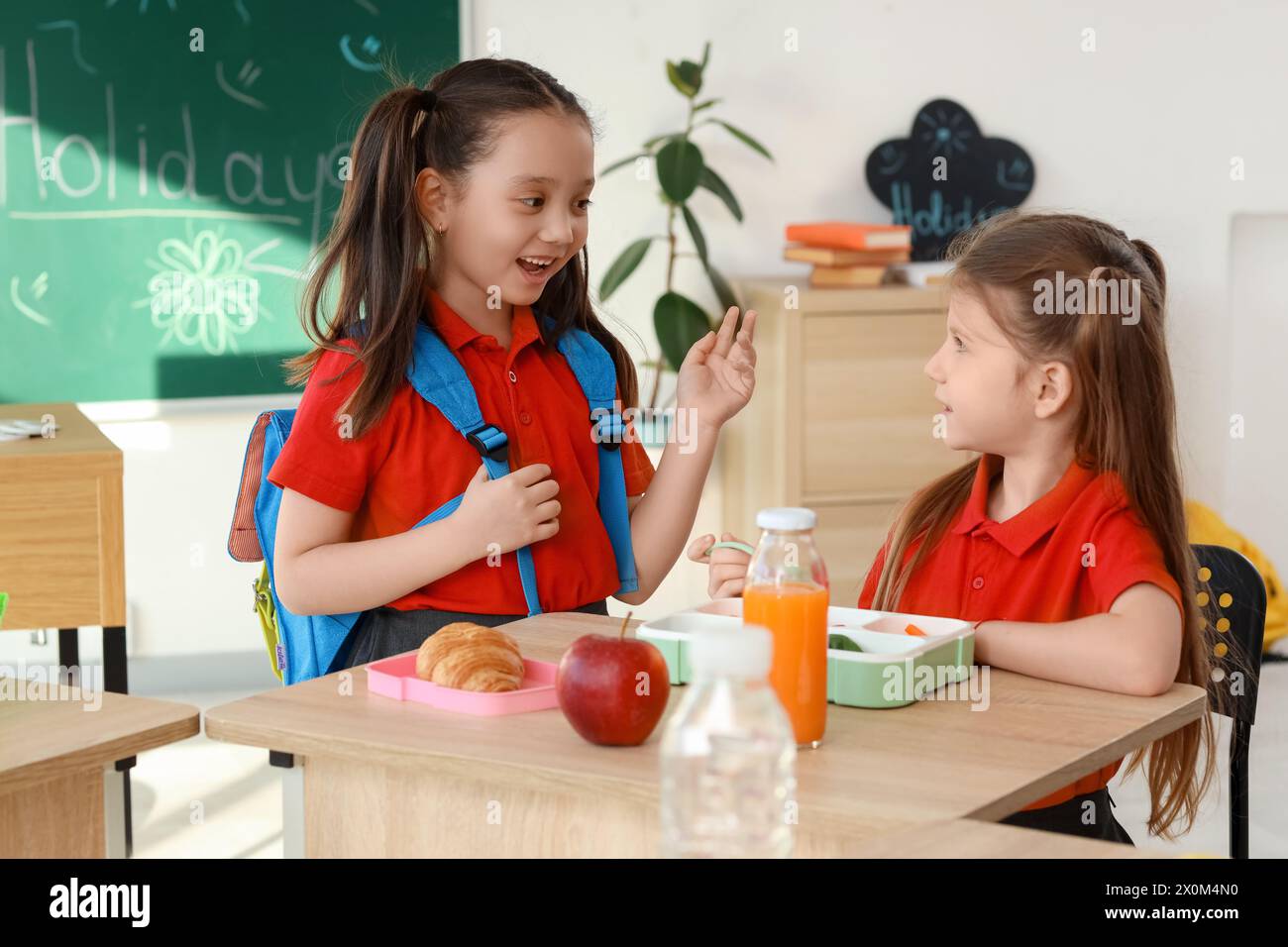 Cute little schoolgirls having lunch in classroom Stock Photo - Alamy