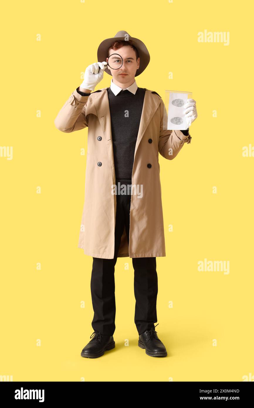 Male spy with magnifier and fingerprints on yellow background Stock ...