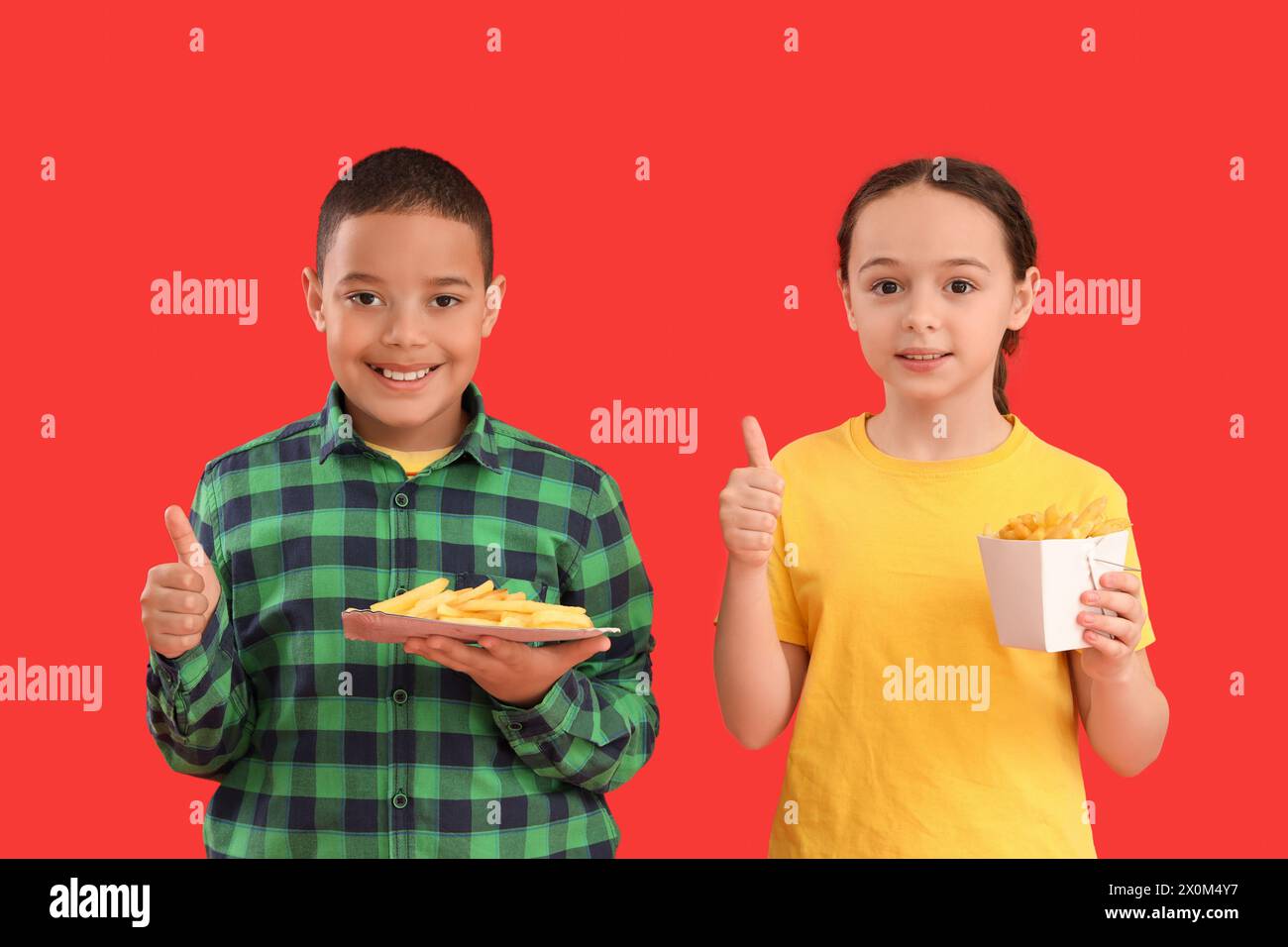 Happy little children with french fries showing thumbs-up gesture on ...