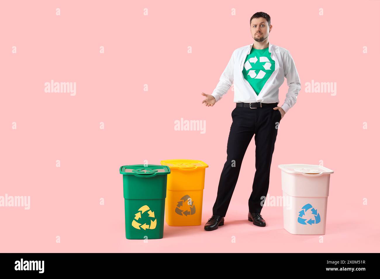 Confused young man in t-shirt with recycling sign and garbage bins on ...
