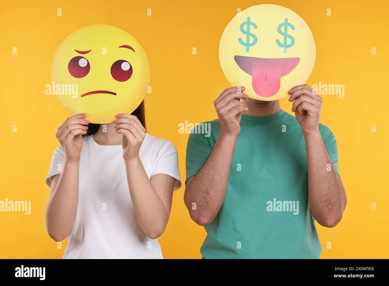 People covering faces with emoticons on yellow background Stock Photo ...