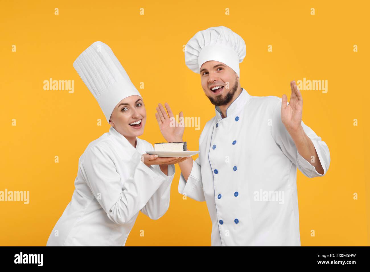 Happy professional confectioners in uniforms holding delicious ...